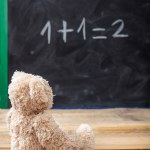 Math test. Cute teddy wearing glasses and black chalkboard Stock Photo ...