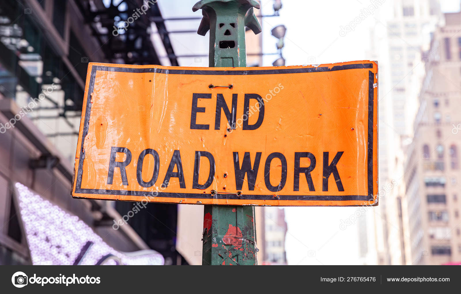 End Road Work. Warning sign, orange color, blur buildings background ...