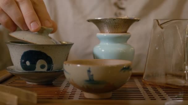 Close up master pouring infusion chinese tea from gaiwan to fairness ...