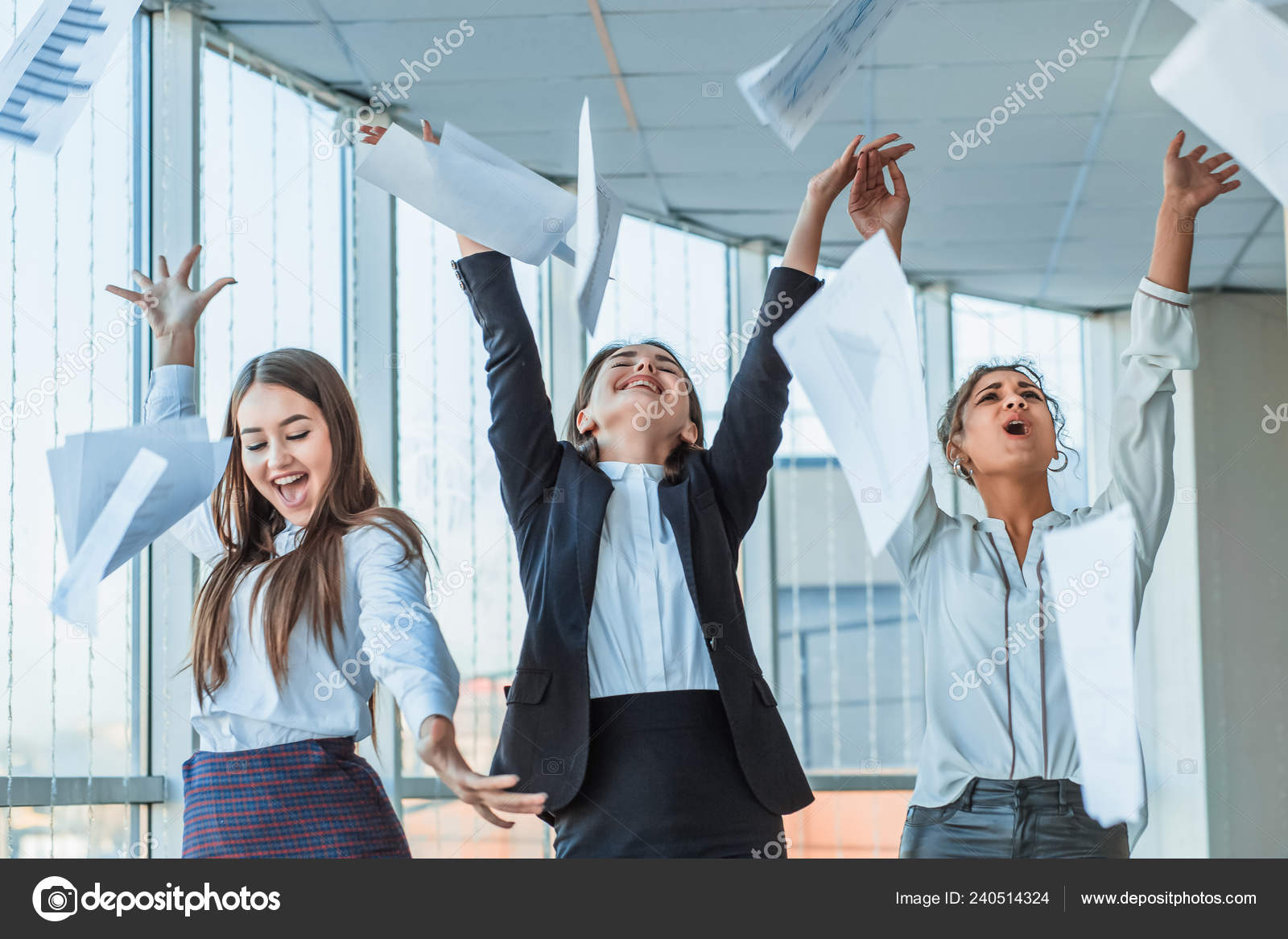 Three young beautiful brunette business ladies in the office. All happy ...