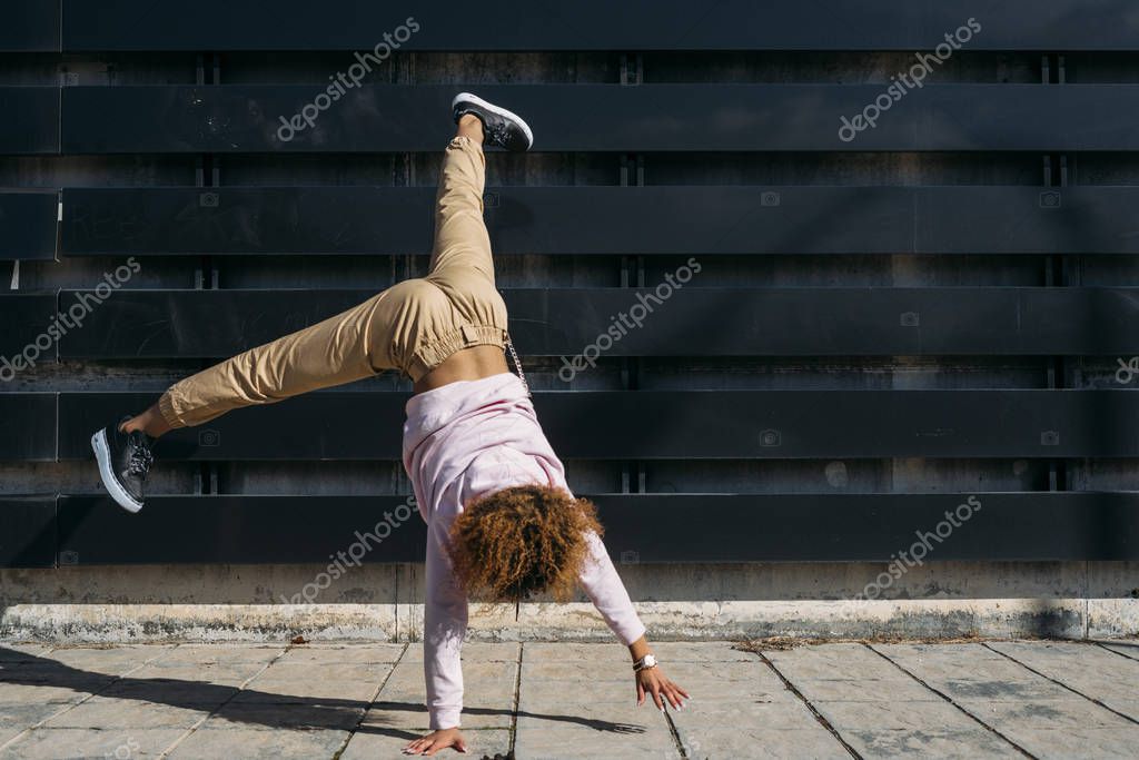 Mujer joven bailarina de breakdance, actuación de breakdance al revés ...