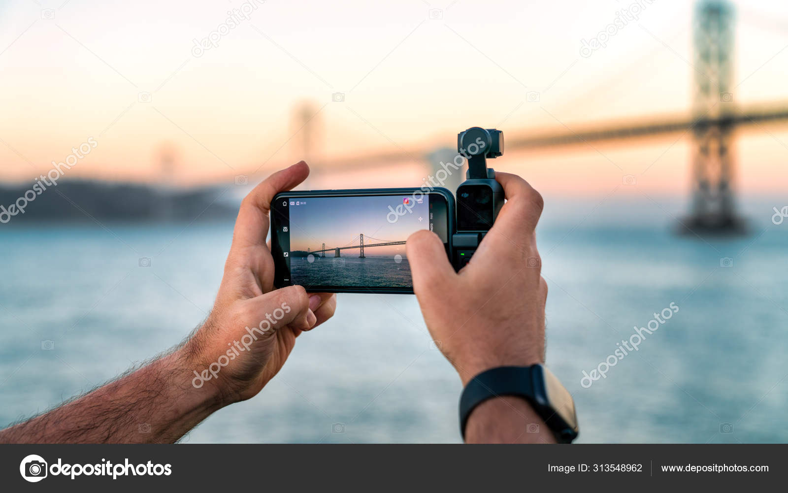 A photographer is using DJI Osmo Pocket to take footage of a Bay Bridge ...