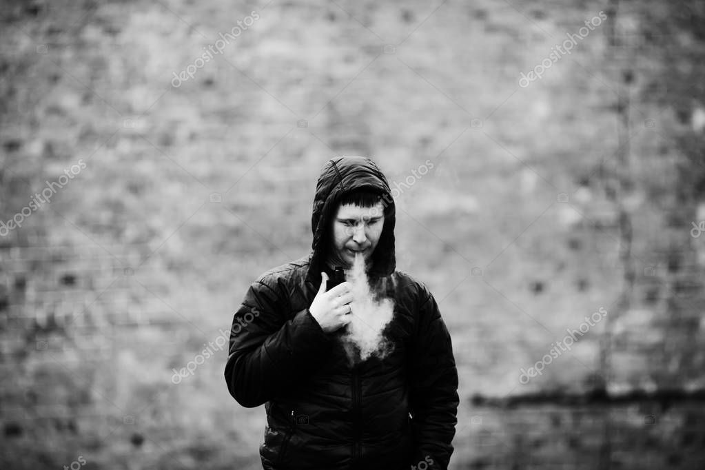 Hombre Vape. Joven chico blanco caucásico en chaqueta negra con una ...