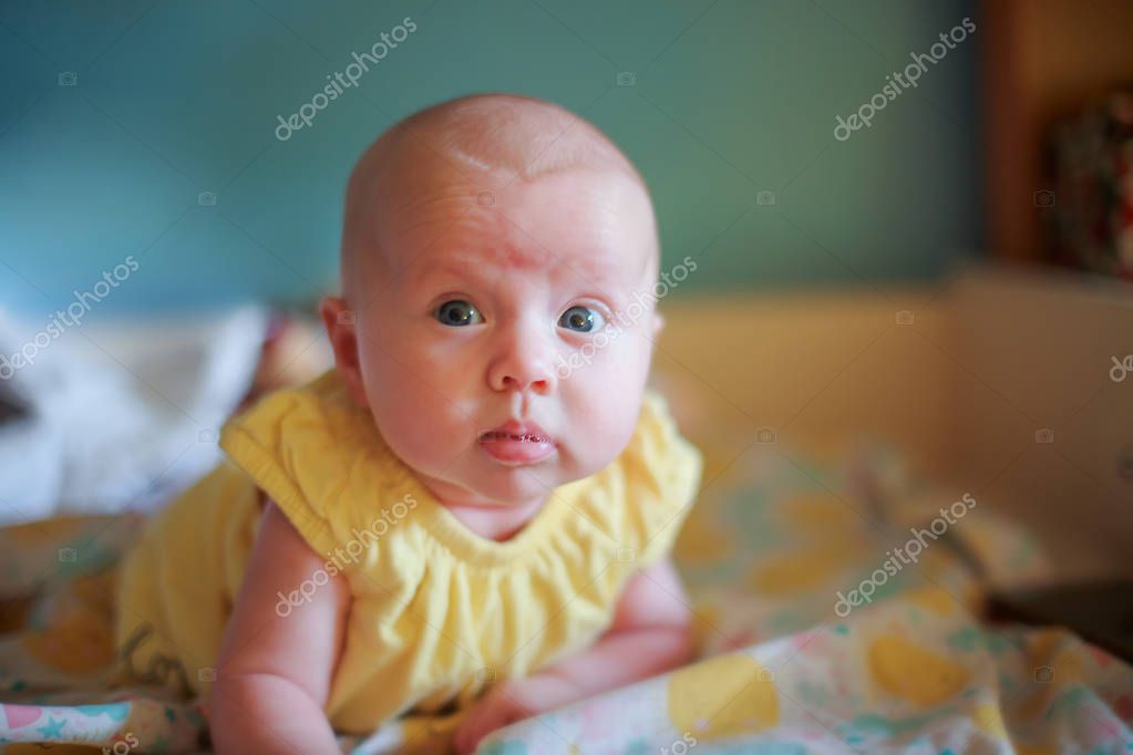 Un bebé con ropa amarilla está acostado en un cambiador en el ...