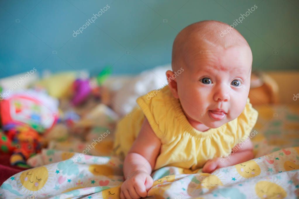 Un bebé con ropa amarilla está acostado en un cambiador en el ...