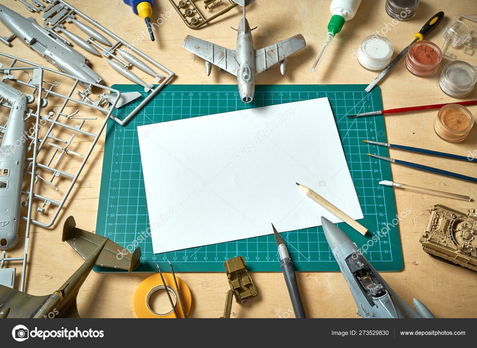 Top view on plastic model scale with accessories on green pad on wooden ...