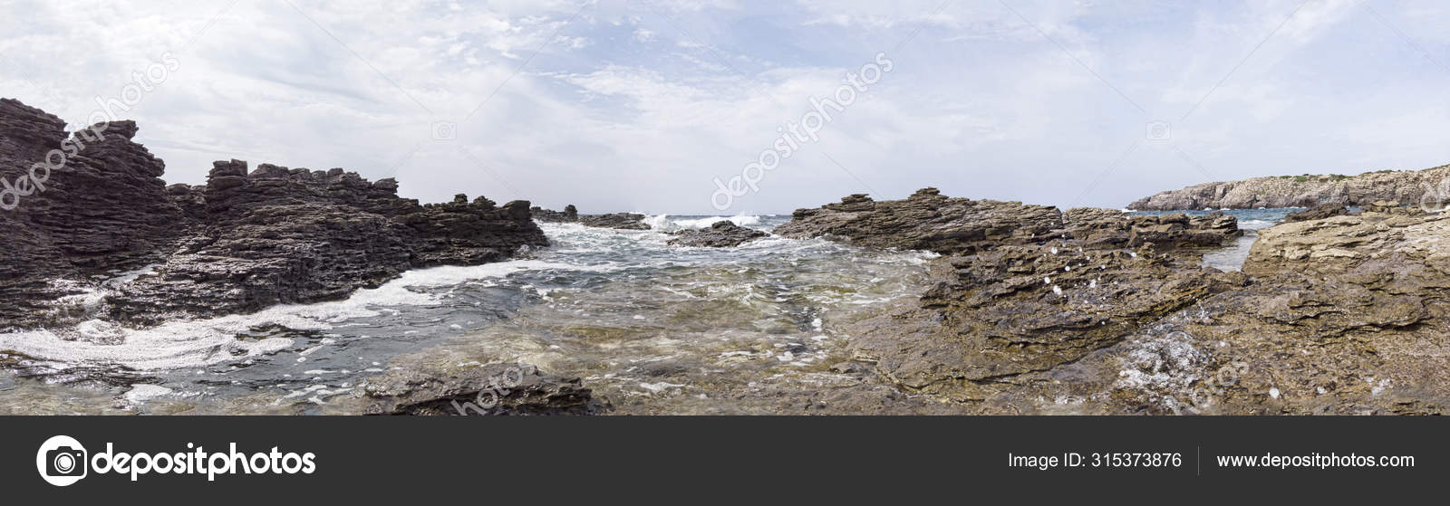 The rough seas breaks on the rocks sculpted by the wind forming a ...