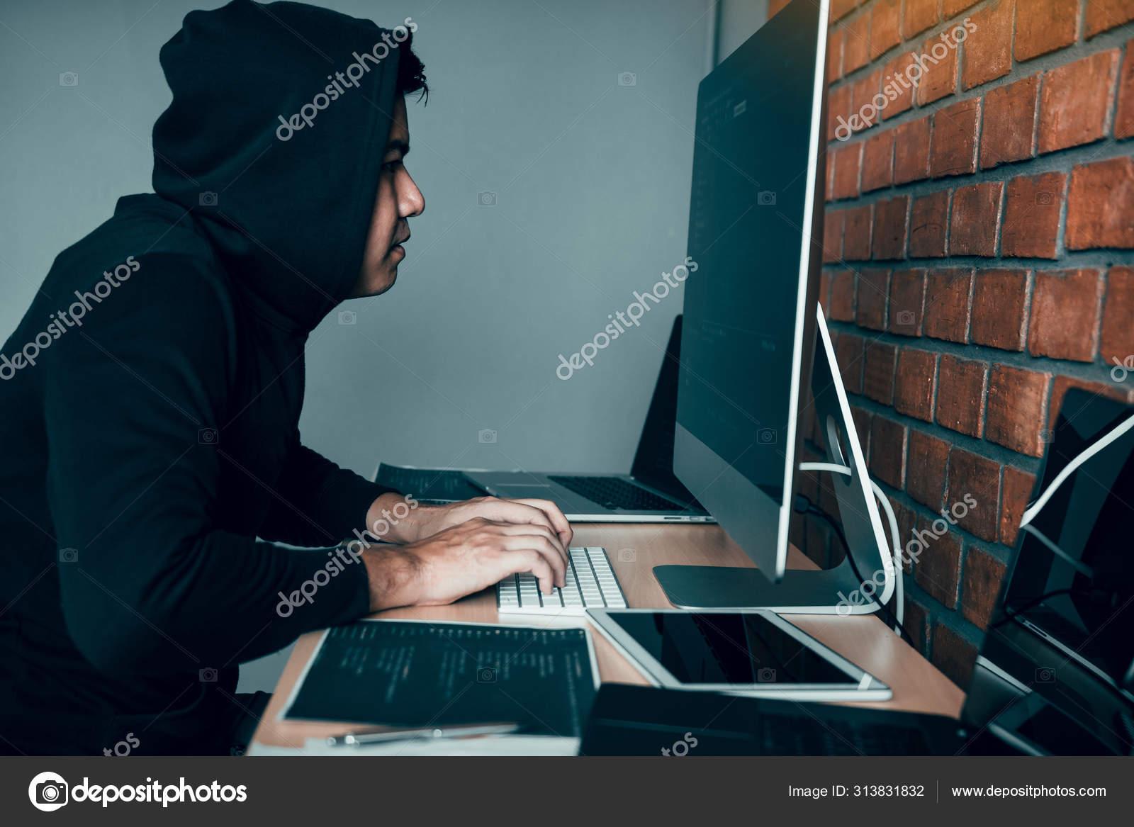 Hacker in the hood working with computer with hacking breaking i ...