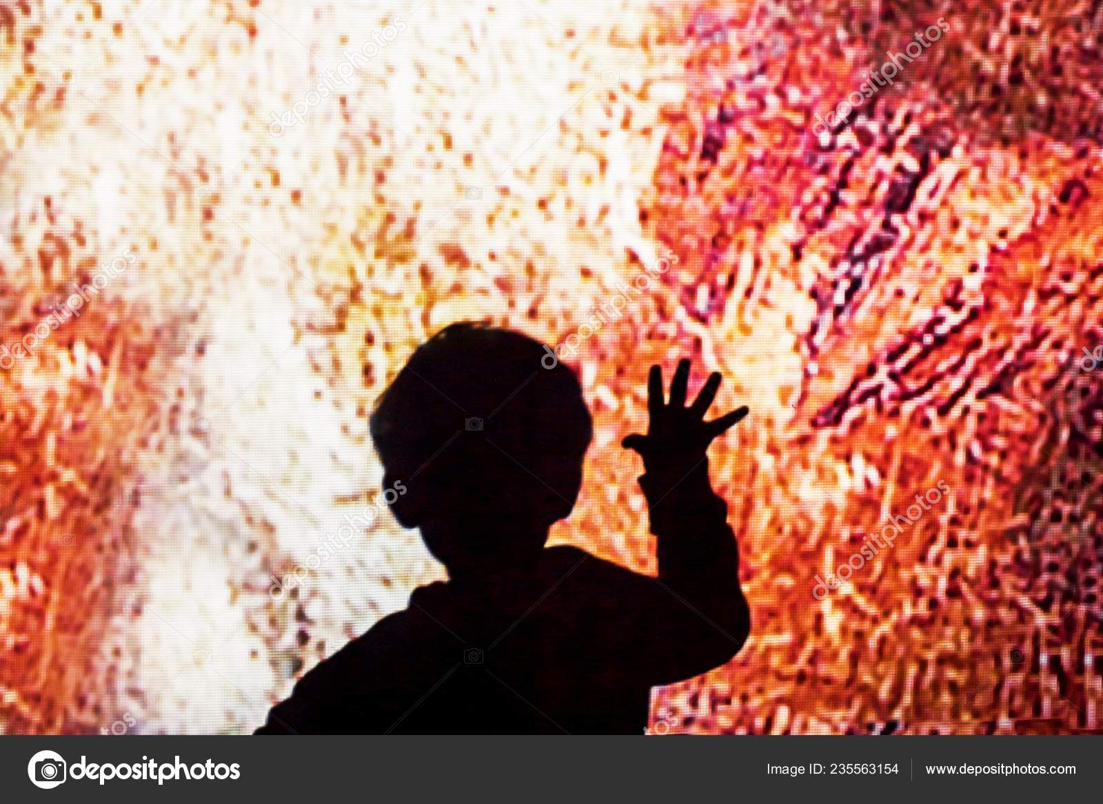 Child touch the big screen. Child hand touches on the colored glass ...
