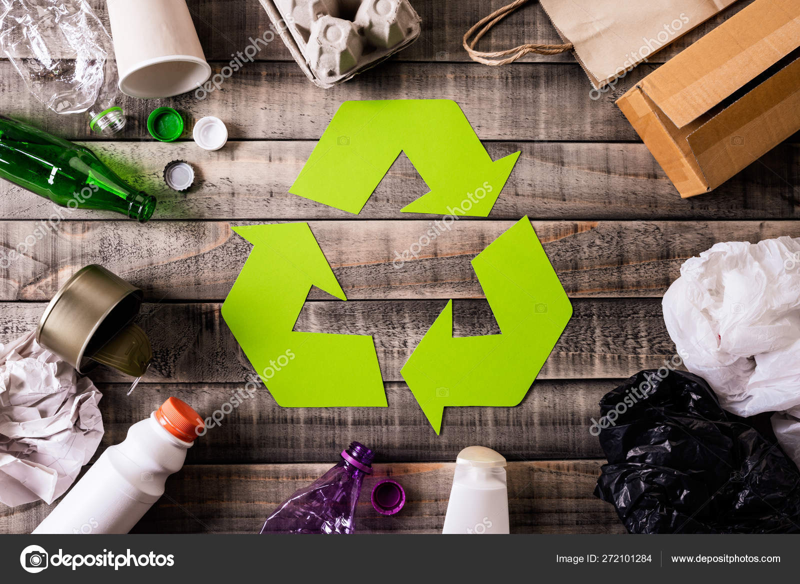 Top view of Different garbage materials with recycling symbol on table ...