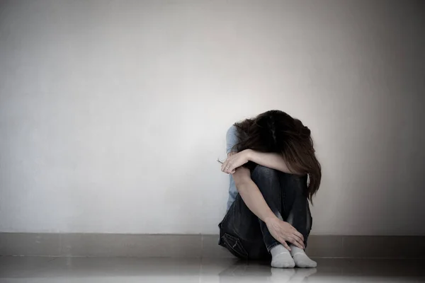 Sad woman hug her knee and cry. Sad woman sitting alone in a empty room ...