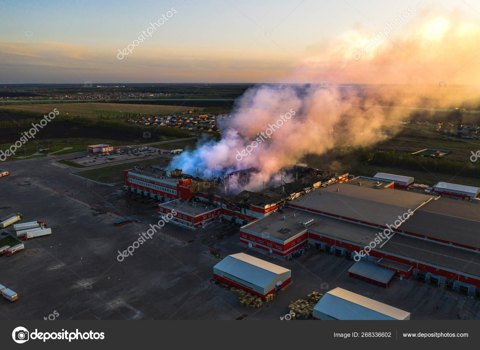 Burning industrial building with fire, huge thick smoke and burnt roof ...
