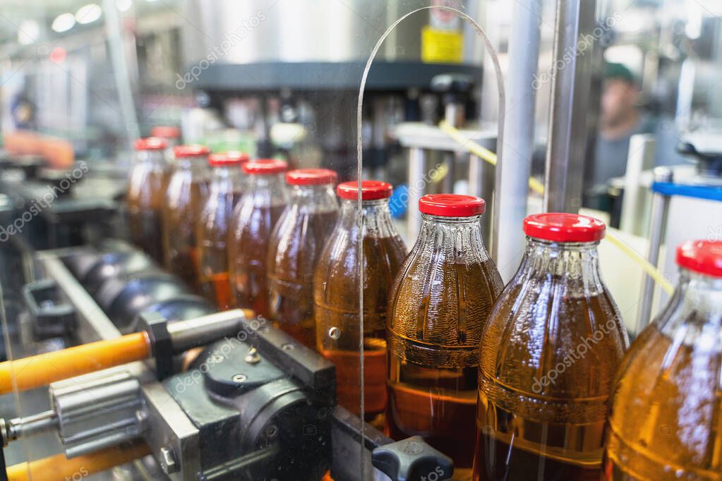 Cinta transportadora, jugo en botellas de vidrio en la planta de bebidas o en el interior de la ...