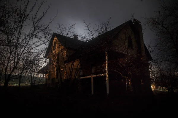 Antigua casa con un Fantasma en el bosque por la noche o Casa de terror embrujada abandonada en ...