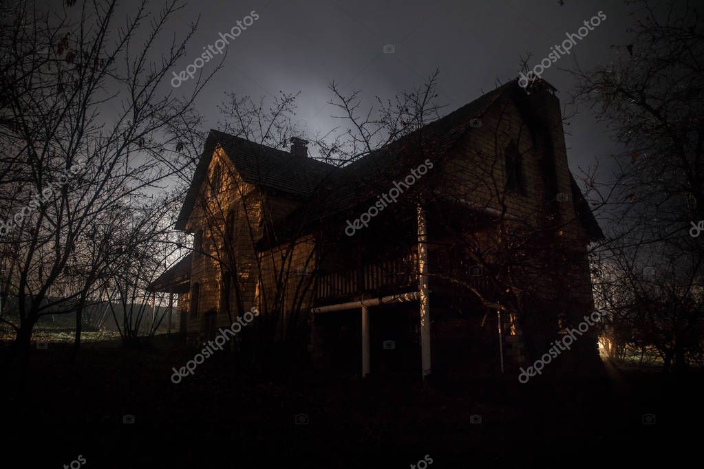 Antigua casa con un Fantasma en el bosque por la noche o Casa de terror embrujada abandonada en ...