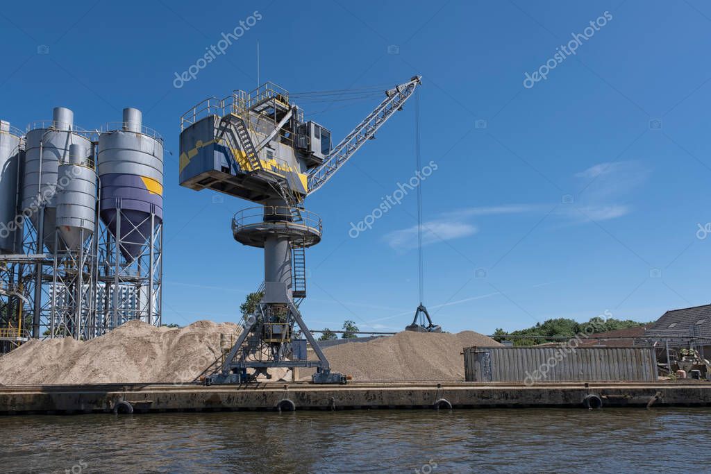 Grúa de manipulación a granel que descarga arena, metal de carretera y ...