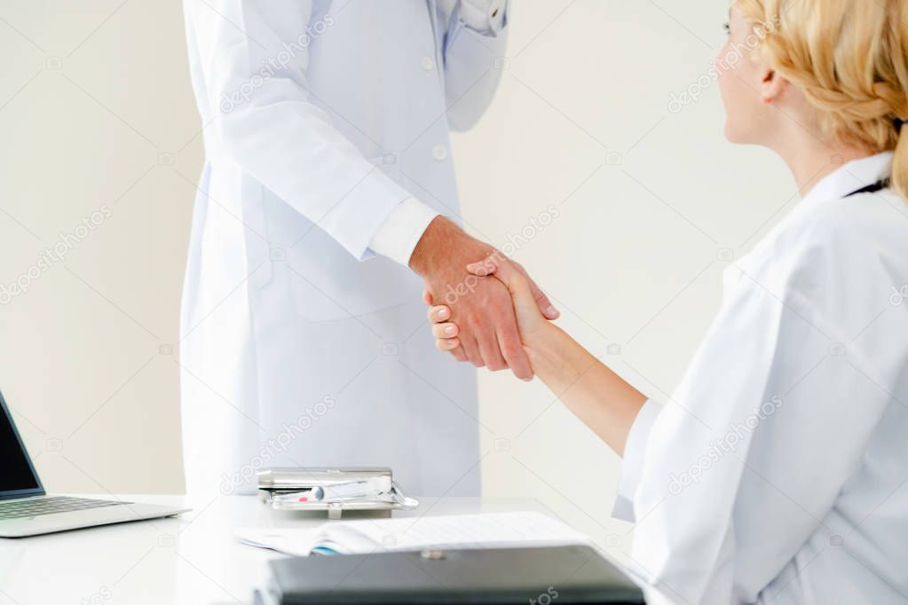 Médico en el hospital dando apretón de manos a otro médico que muestra ...