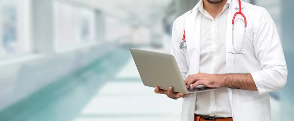 Doctor using laptop computer at the hospital. Medical healthcare and ...