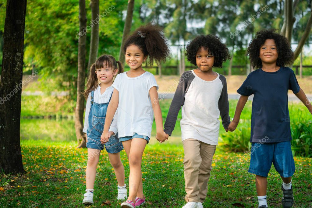 Feliz grupo afroamericano de niños y niñas jugando en el patio de recreo de la escuela. Concepto ...