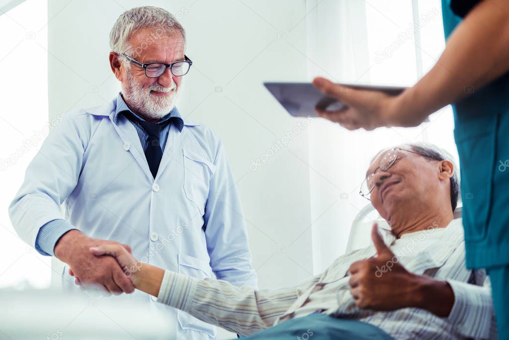 M dico maduro hablando y examinando la salud del paciente mayor en la sala de hospital. Concepto ...