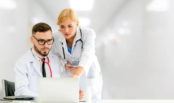 Doctors working with laptop computer in hospital. - Stock Image ...