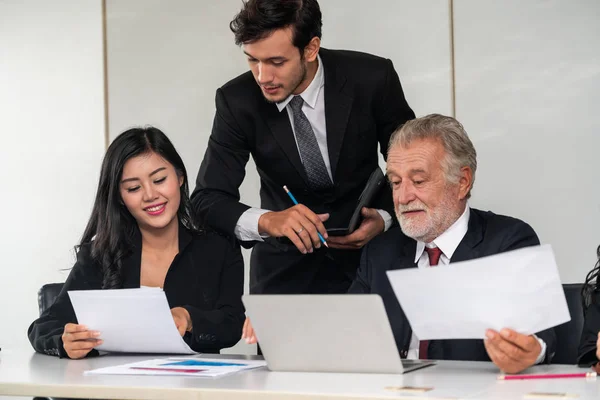 Senior caucasian manager working in office with assistance of young ...