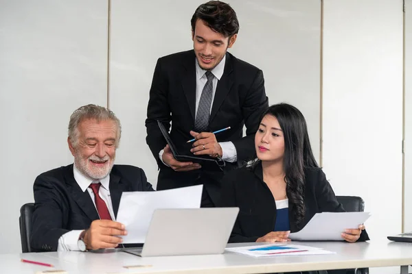 Senior caucasian manager working in office with assistance of young ...