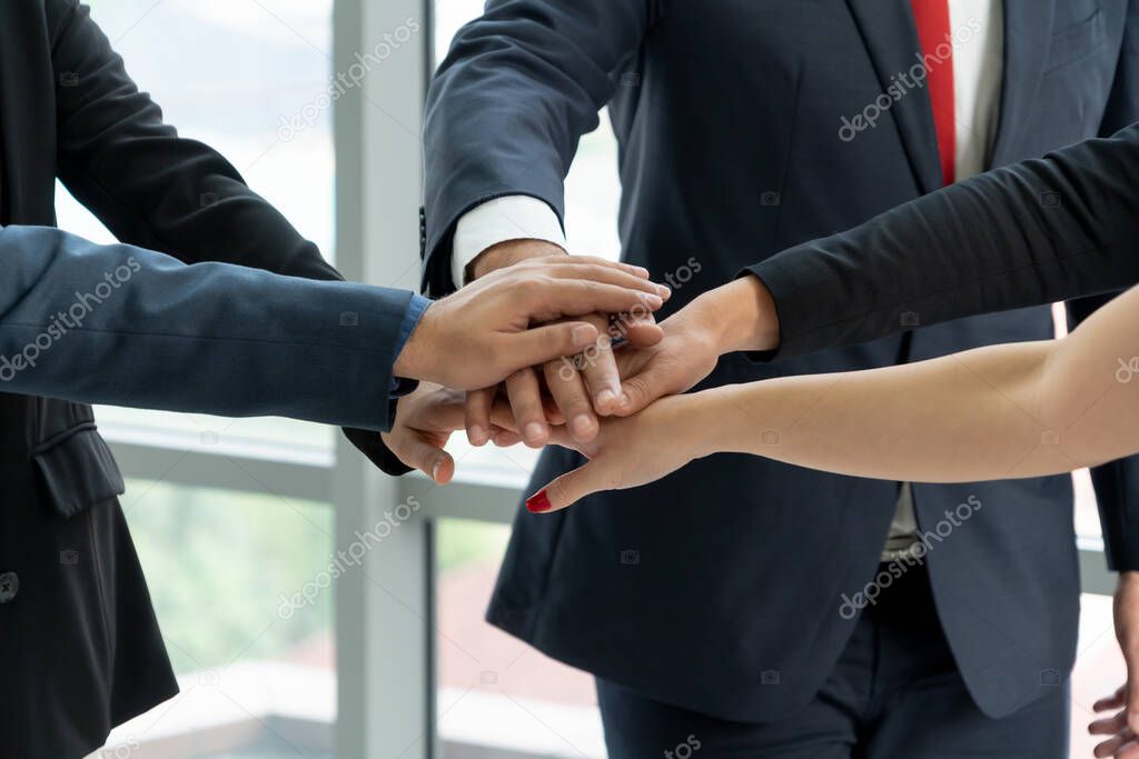 Muchos empresarios felices unen sus manos con alegría y éxito. Empleado ...