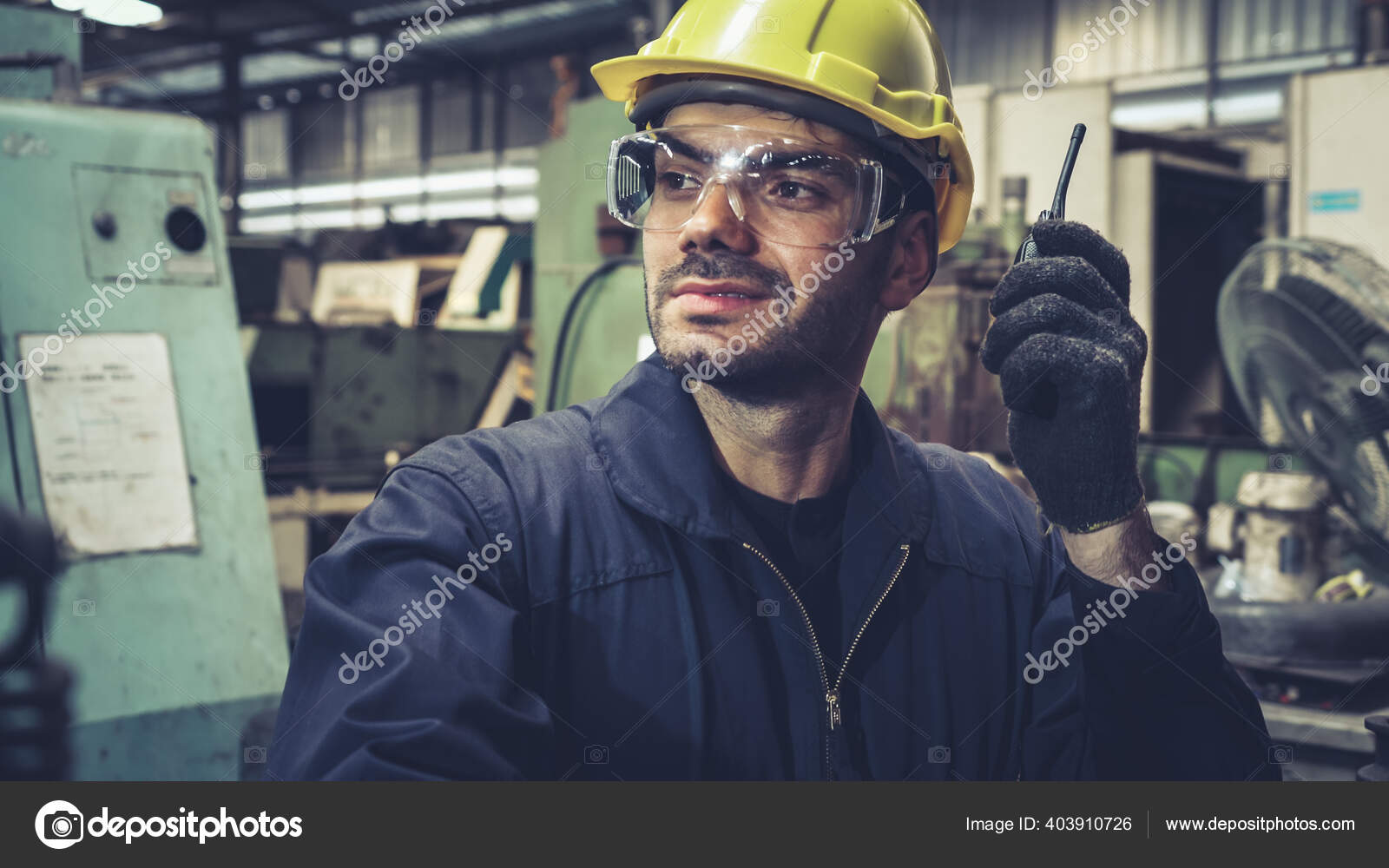 Factory Worker Talking Portable Radio While Inspecting Machinery Parts ...
