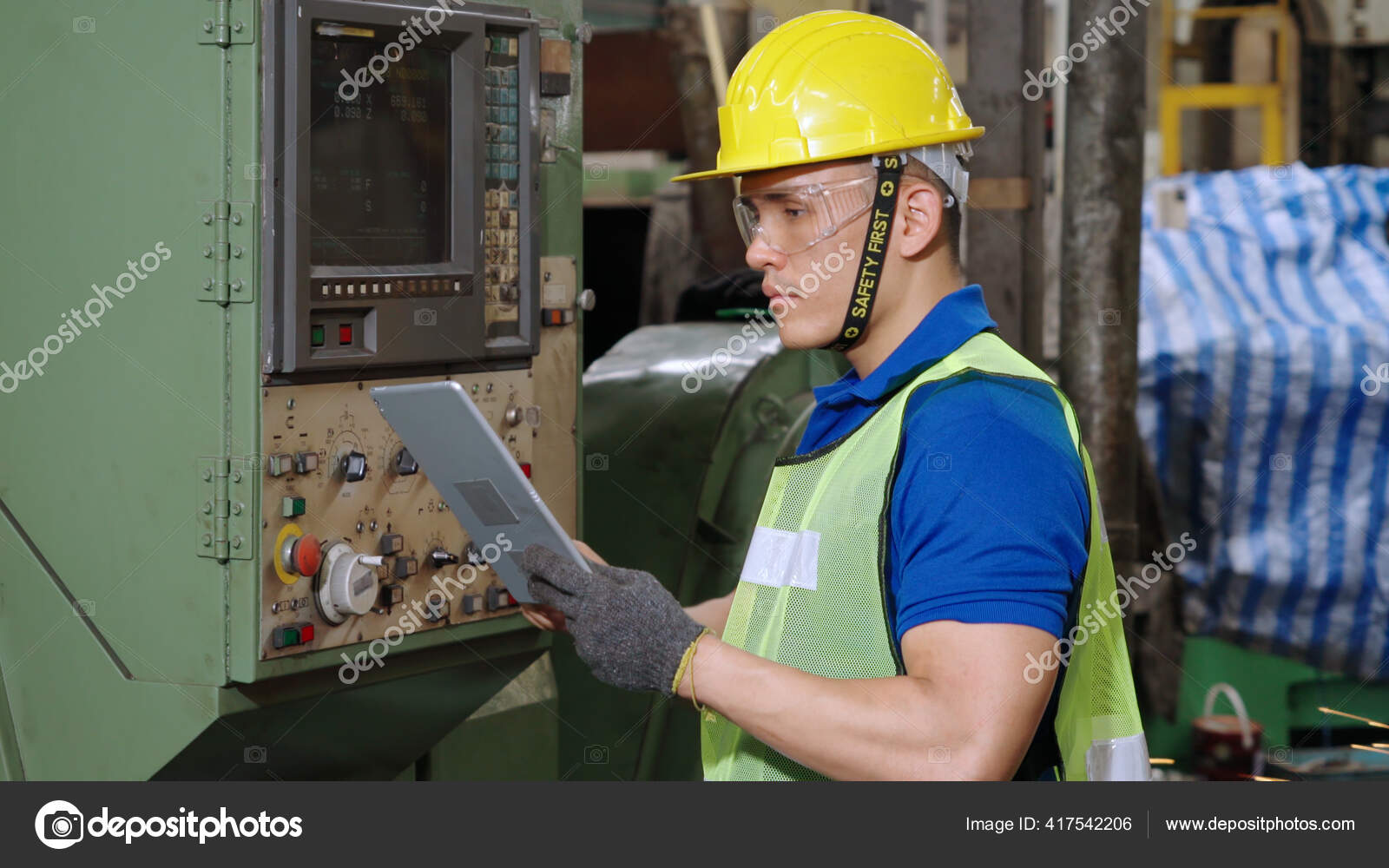 Smart factory worker using machine in factory workshop Stock Photo by ...
